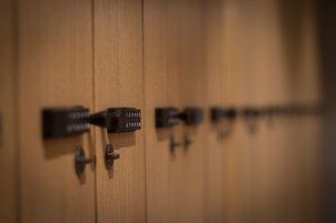 Uma fileira de portas de madeira com fechaduras numeradas, provavelmente indicando números de quarto.