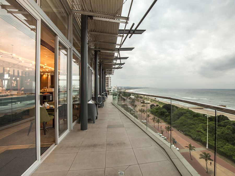 Uma varanda com vista para a praia e o oceano.