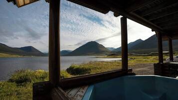 Uma cabana com vista para um lago e montanhas.