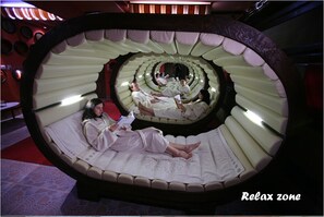 Espaço de relaxamento circular com assentos acolchoados e uma área central para leitura.