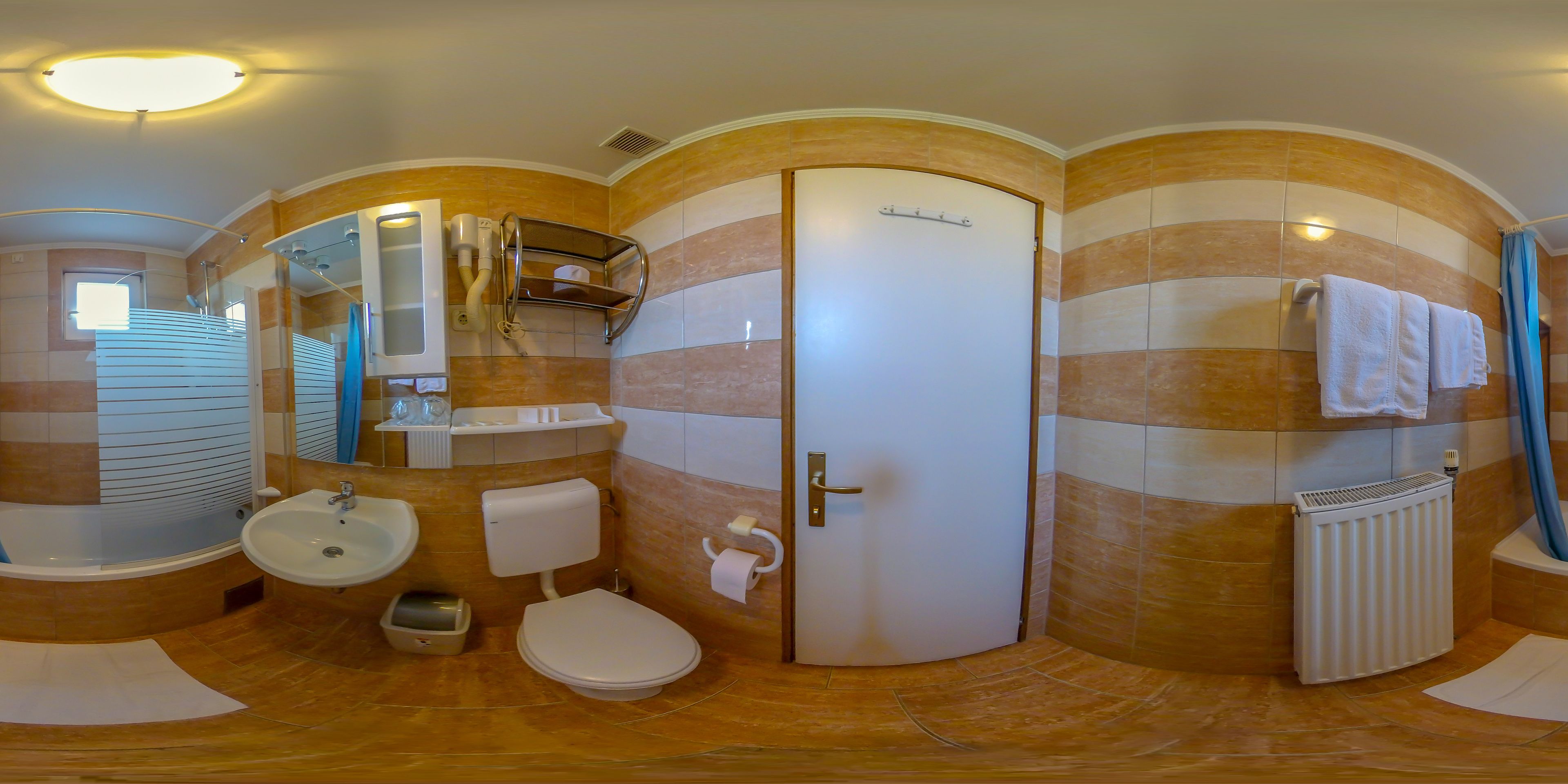 Casa de banho com sanita, lavatório e chuveiro.