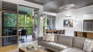 Uma sala de estar moderna com sofá, mesa de centro e área de refeições.