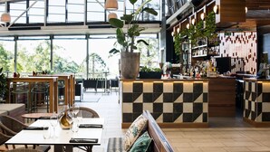 Um espaço amplo e interno com bar, assentos e grandes janelas.