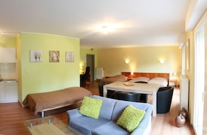 Um espaço compacto para viver, com cozinha compacta, sofá, mesa de jantar e cama.