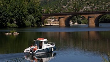 Um barco em um rio calmo com uma ponte ao fundo.