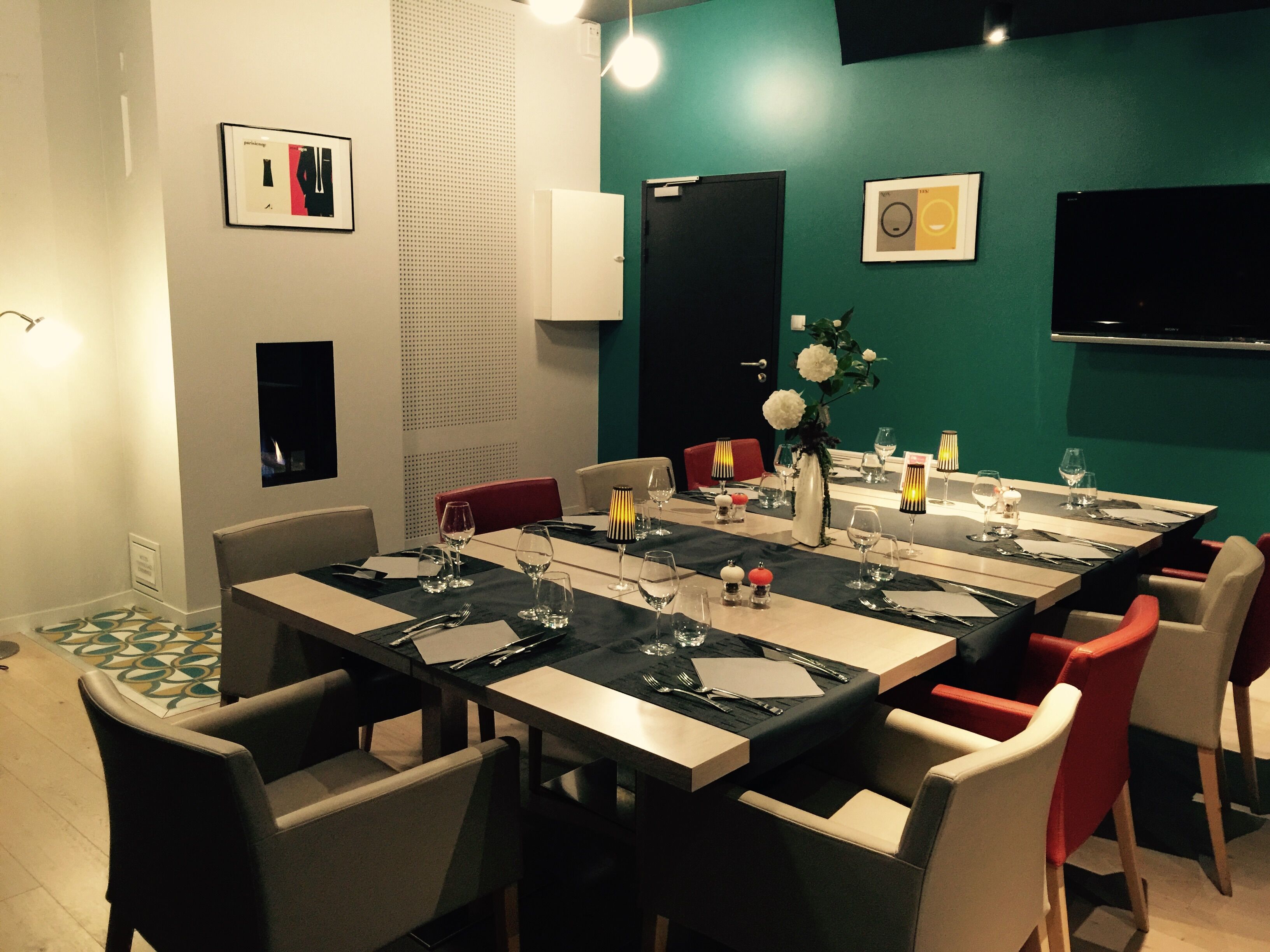 Sala de conferência com uma longa mesa preparada para uma reunião, equipada com cadeiras e tela de projeção.