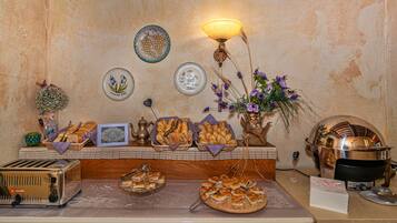 Buffet de café da manhã com pães, bolos e sanduíches.