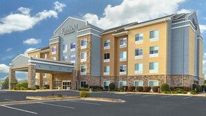 Um hotel Fairfield by Marriott com fachada de pedra, várias janelas e um estacionamento.