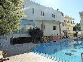 Um edifício moderno com piscina, área de estar externa e bar.