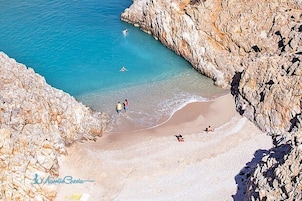 Uma praia com falésias rochosas e águas azul-claras.