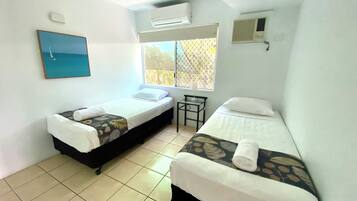 Quarto pequeno e limpo com duas camas, janela com vista e ar condicionado.