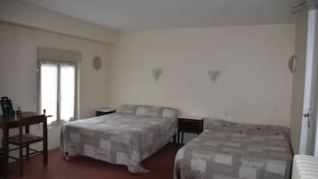 Quarto com duas camas, uma escrivaninha e uma cadeira.