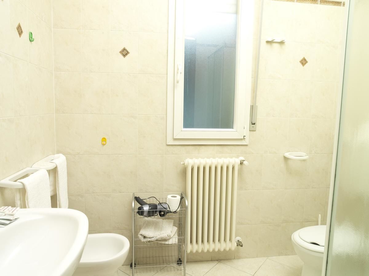 Uma casa de banho com banheira, sanita, chuveiro e radiador.