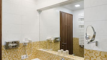 Uma casa de banho moderna com uma sanita branca, um espelho e um porta-toalhas.
