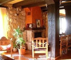 Um interior rústico com paredes de pedra, móveis de madeira e lareira.