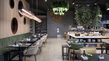Um restaurante com um balcão extenso, diversas áreas de estar e uma variedade de opções de comida e bebida.