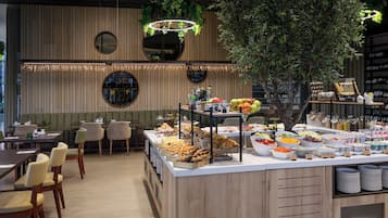 Uma área de buffet com diversos alimentos e um espaço de estar com cadeiras e mesas.