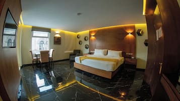 Quarto de hotel moderno com uma cama grande, uma escrivaninha e uma cadeira.