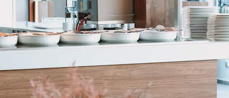 Uma cozinha moderna com bancada de madeira, pratos brancos e plantas em vasos.