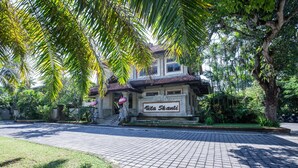 Uma villa com entrada pavimentada e uma placa com a inscrição 'Villa Shanti'.