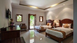Quarto de hotel com duas camas, uma escrivaninha, uma cadeira e uma televisão.
