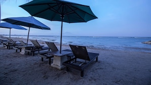 Uma praia com cadeiras de praia e guarda-sóis.