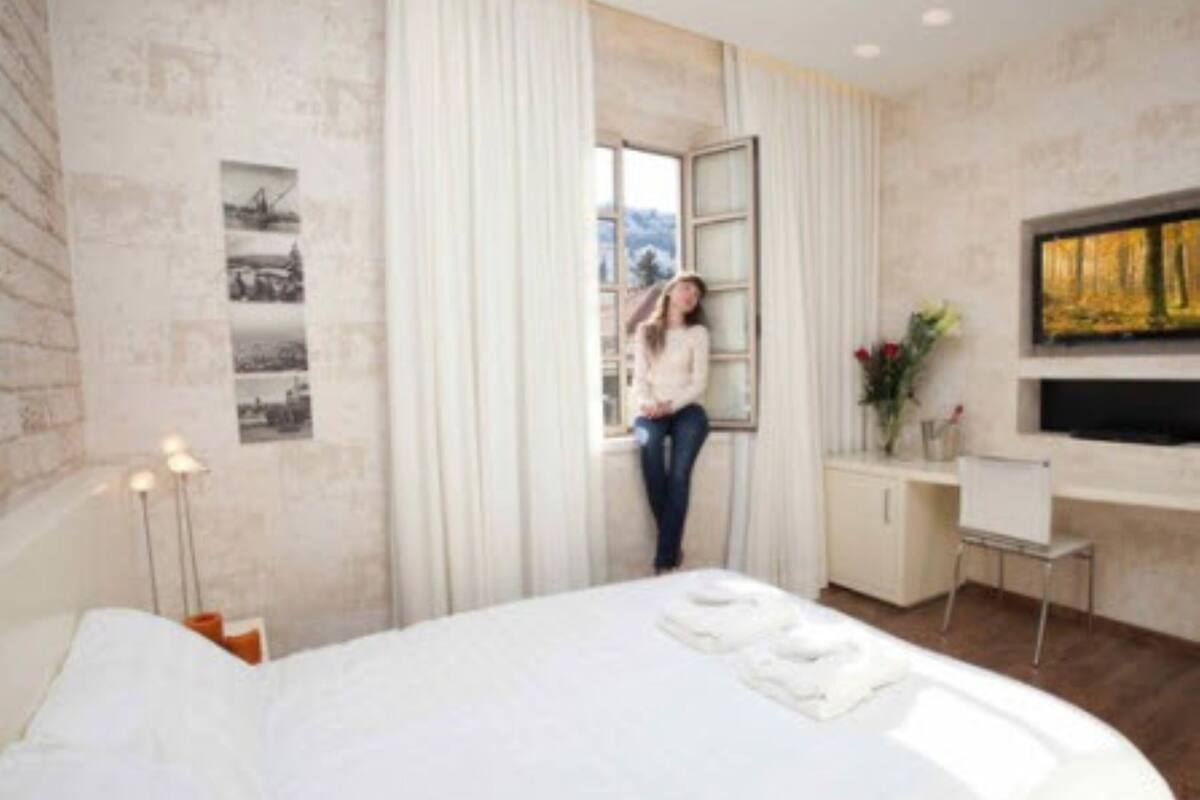 Quarto de hotel moderno com uma cama grande, uma escrivaninha e uma janela com cortinas.