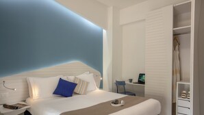 Quarto de hotel moderno com uma cama grande, uma mesa de trabalho e um closet espaçoso.