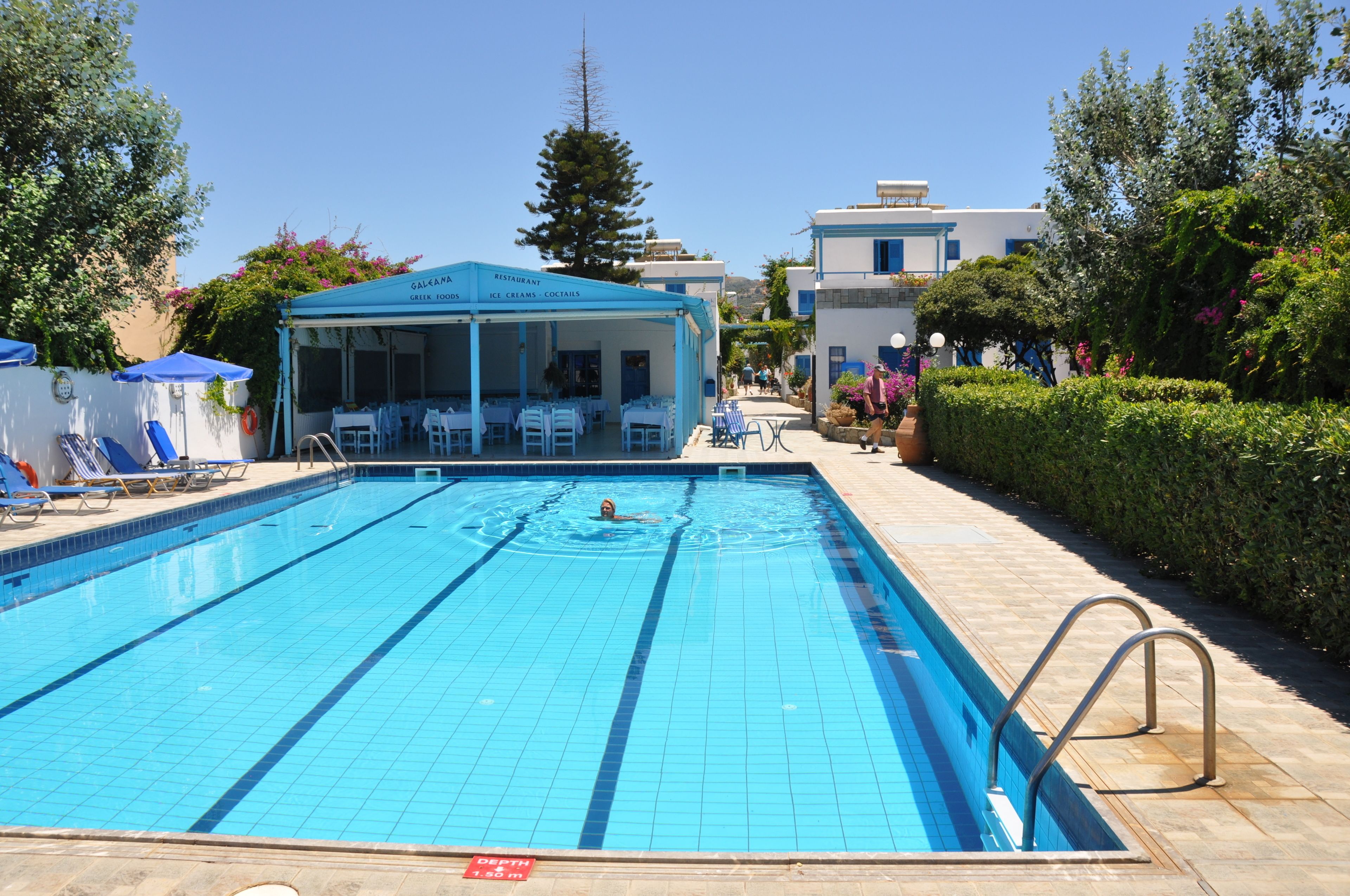 Piscina com área coberta, espreguiçadeiras e posto de salva-vidas.