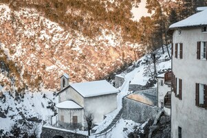 Um edifício coberto de neve com uma escadaria de pedra íngreme que leva até ele.