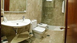 Casa de banho com lavatório, sanita e chuveiro.