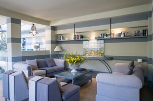 Uma sala de estar moderna com um sofá seccional, uma mesa de centro com um vaso de flores amarelas e estantes embutidas.