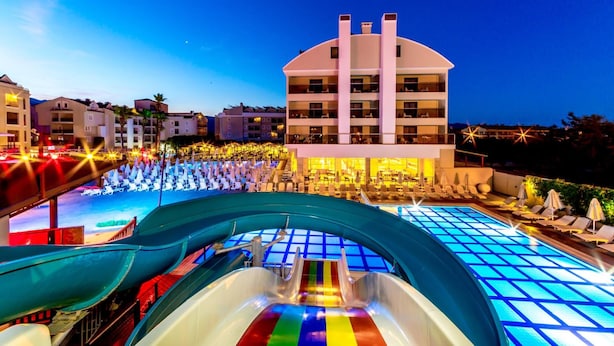Um hotel com área de piscina, incluindo um toboágua e um solário com espreguiçadeiras.