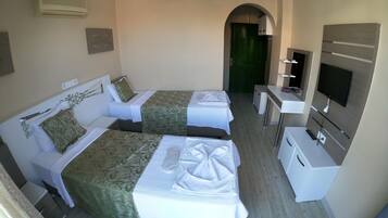 Quarto de hotel com duas camas, uma escrivaninha, uma TV e um ar condicionado.