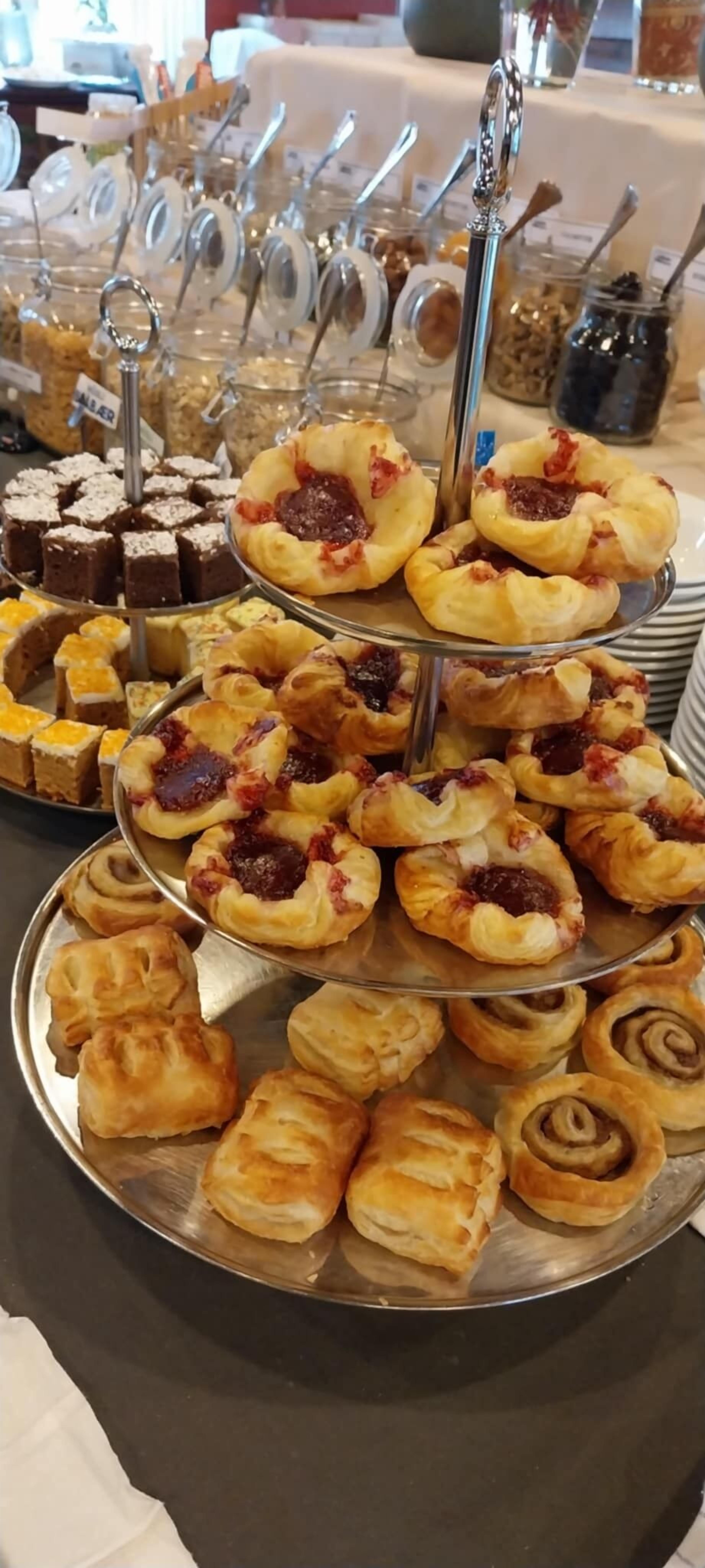 Diversos doces e sobremesas em um prato, incluindo croissants e tartes.