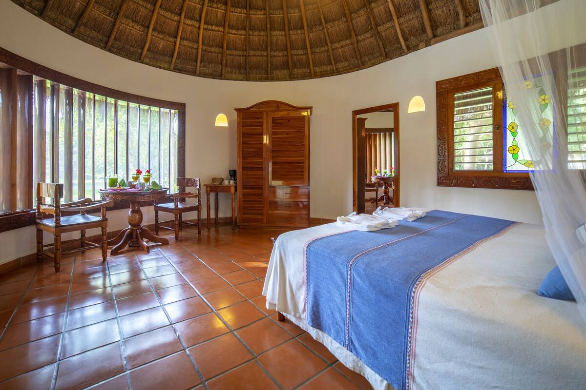 Um quarto com cama, escrivaninha e guarda-roupa.