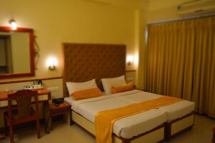 Quarto de hotel com uma cama grande, uma escrivaninha e uma cadeira.