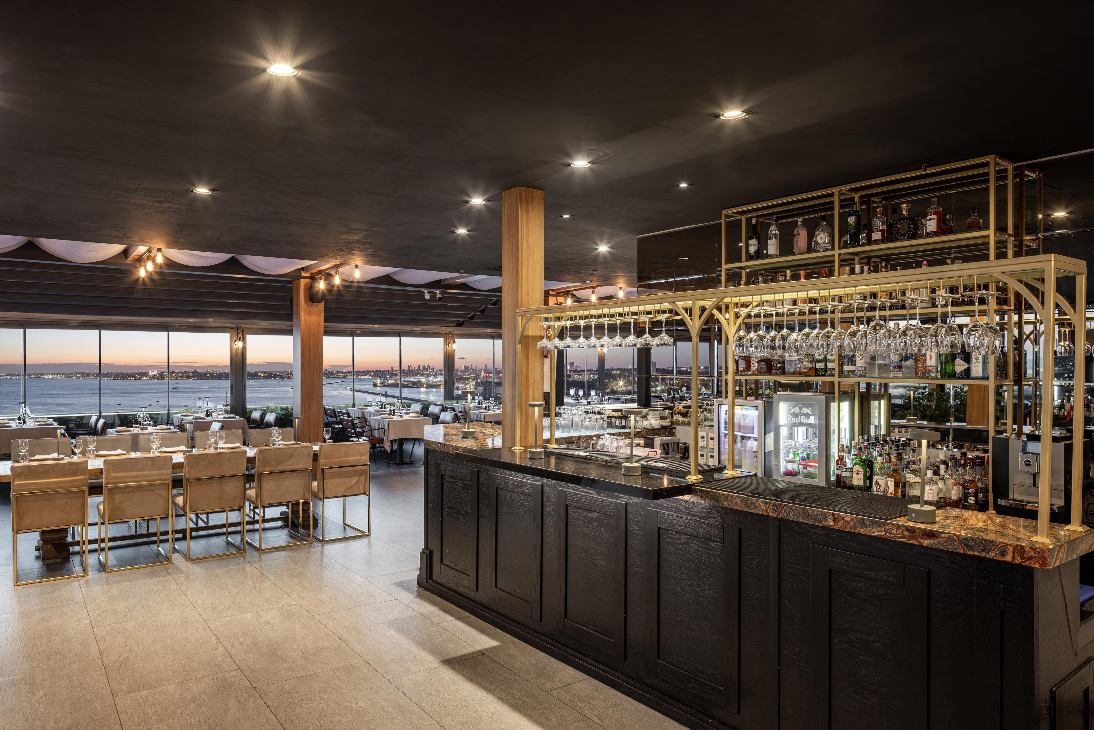 Um bar com vista para o horizonte da cidade e para a orla marítima.