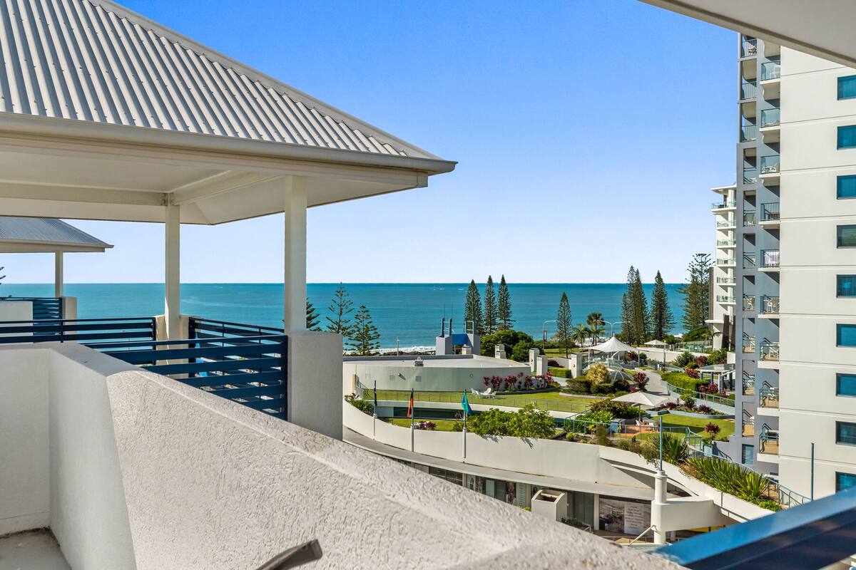 Uma varanda com vista para o mar e uma área de resort.