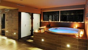 Um spa moderno com hidromassagem, velas e vista do céu noturno através de uma grande janela.