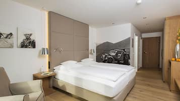 Um quarto moderno com uma cama grande, uma mesa de cabeceira, uma cadeira e uma luminária na parede.