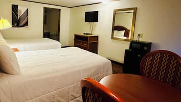 Quarto de hotel com duas camas, uma escrivaninha, uma cadeira, uma televisão, um espelho e uma cômoda.
