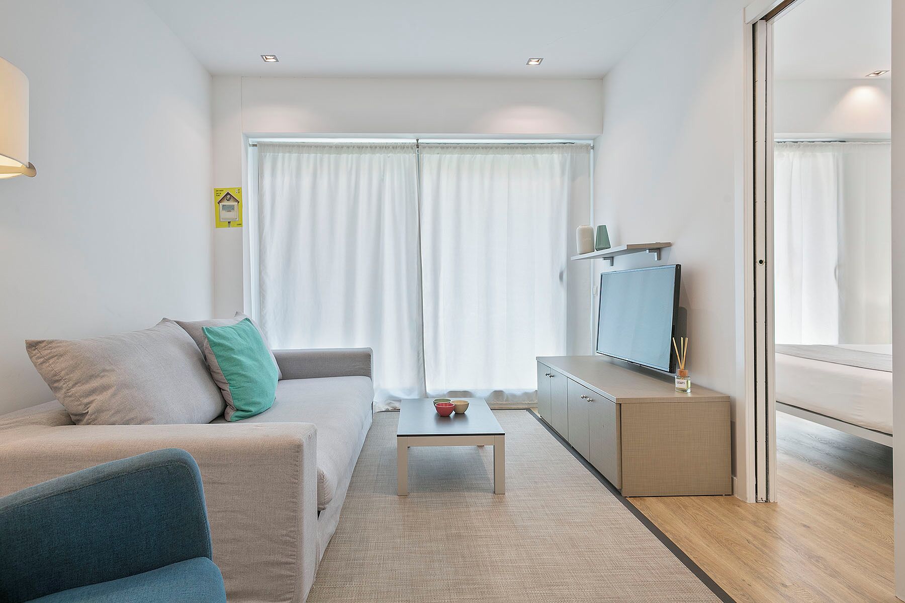 Uma sala de estar moderna com sofá, mesa de centro e televisão.