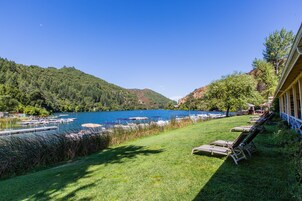 Vista para o lago com cadeiras de descanso e um píer com barcos.