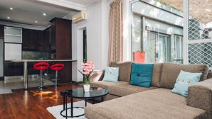 Uma sala de estar moderna com um sofá, uma mesa de centro e banquetas vermelhas.