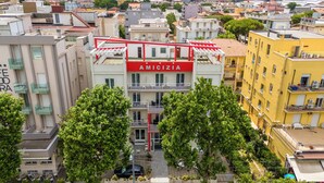 Um edifício com várias andares e varandas, com uma placa vermelha que diz "AMICIZIA".
