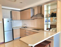 Uma cozinha moderna com eletrodomésticos de aço inoxidável, uma pia embutida e uma despensa com portas de vidro.
