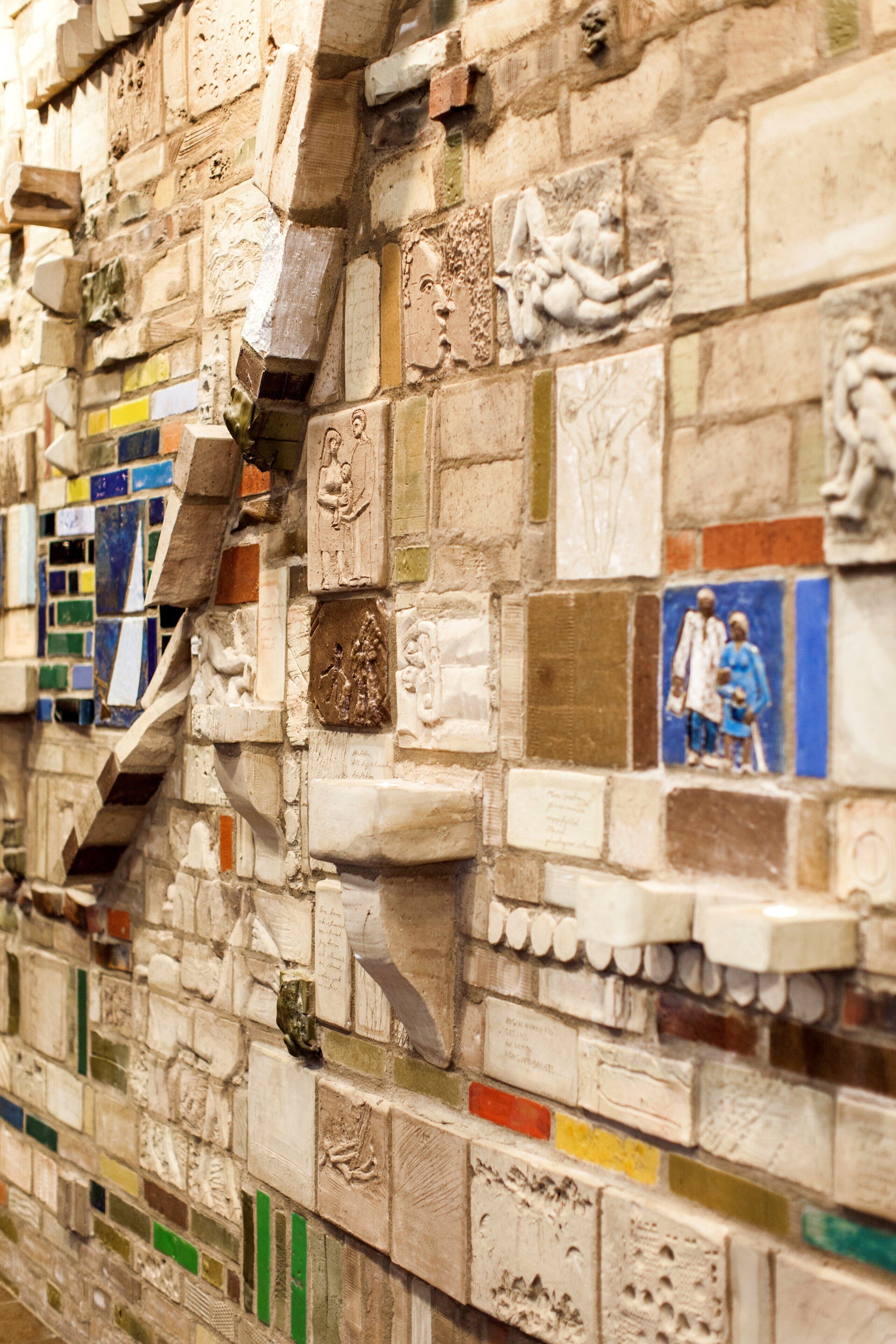 Paredes de mosaico com diversos azulejos de pedra e esculturas em relevo.