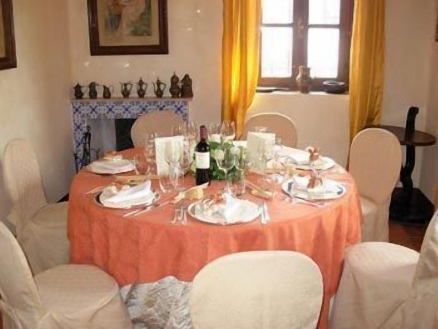 Uma sala de jantar com uma mesa redonda posta para quatro pessoas, cercada por quatro cadeiras.