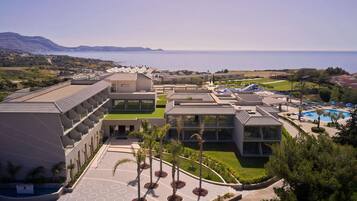 Um resort com piscina, vários edifícios e vista para o mar.